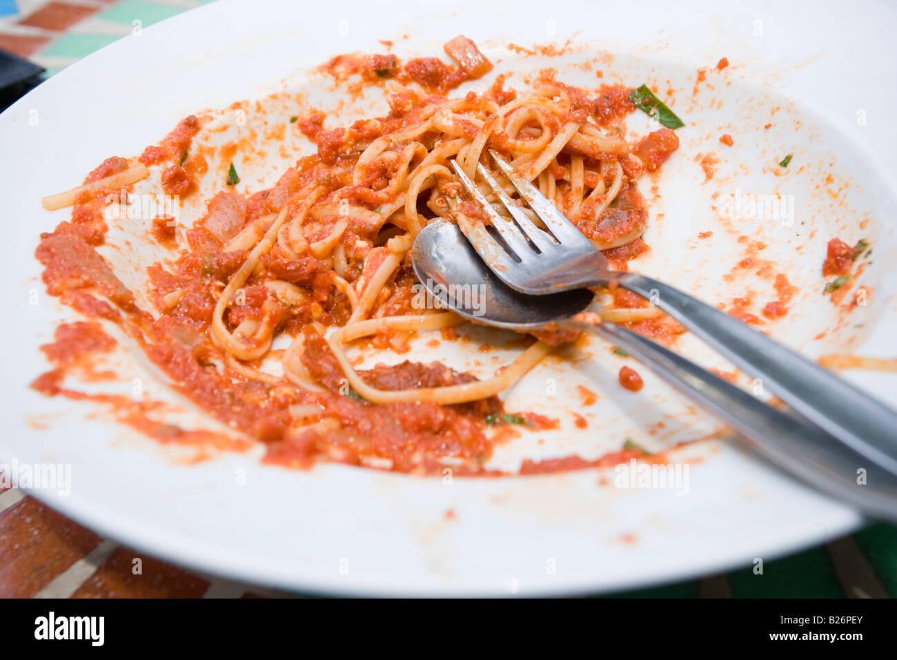 Leftover Pasta on plate with fork and spoon Stock Photo - Alamy
