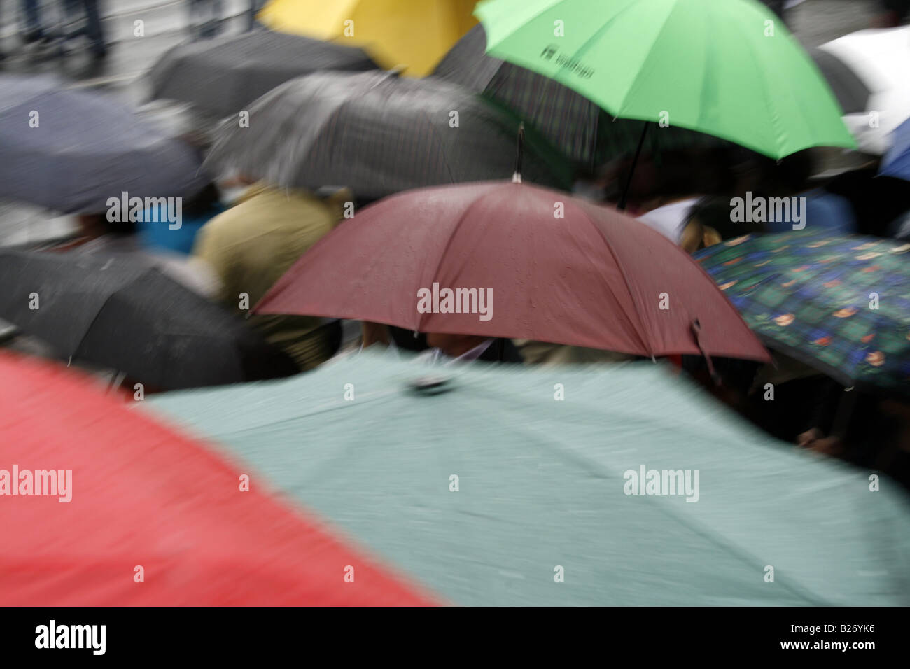 crowd of people with umbrellas in rain in town Stock Photo - Alamy