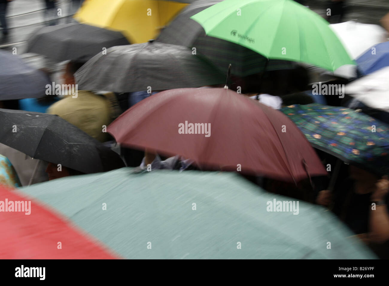 crowd of people with umbrellas in rain in town Stock Photo - Alamy