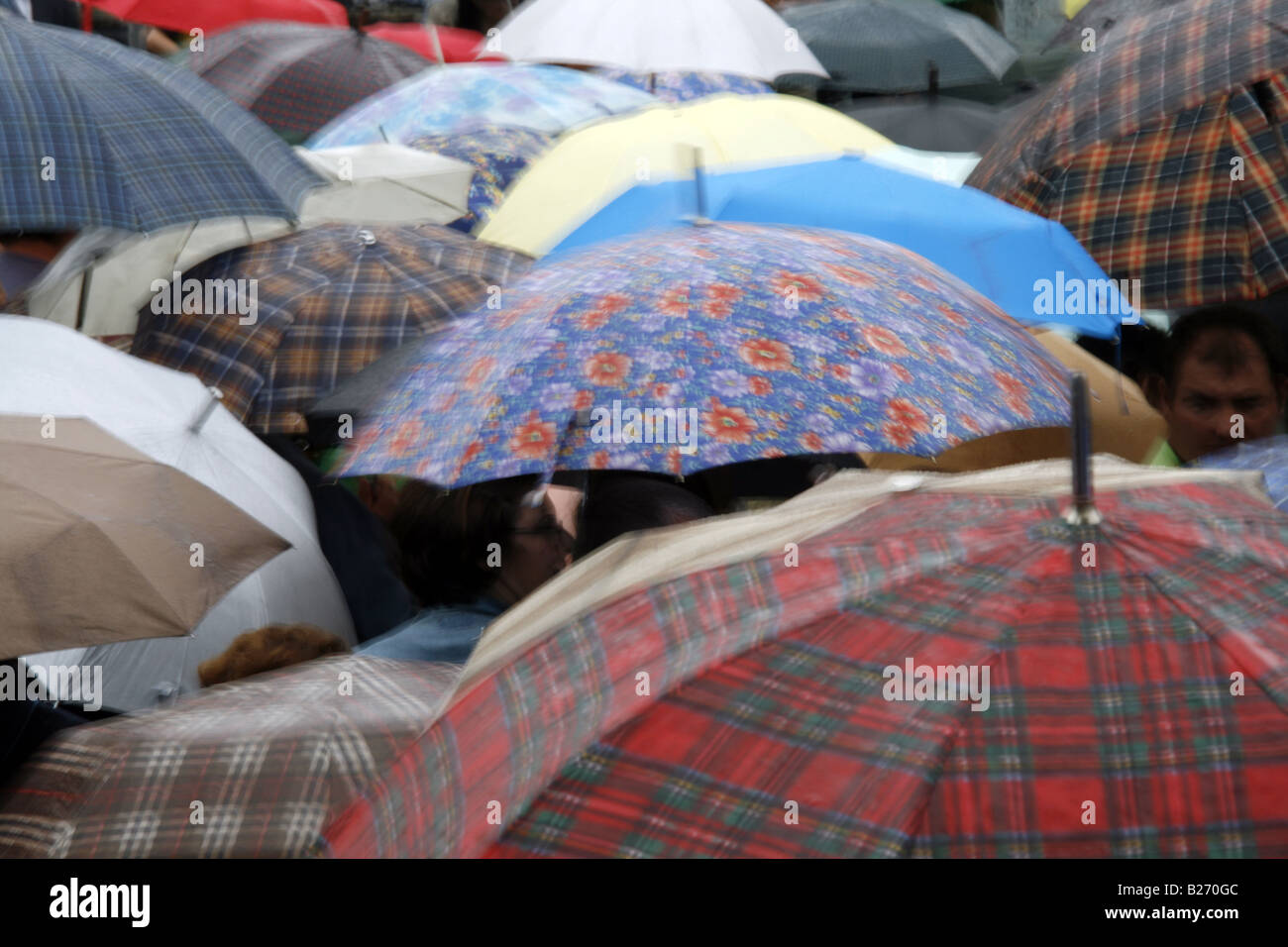 crowd of people with umbrellas in rain in town Stock Photo - Alamy