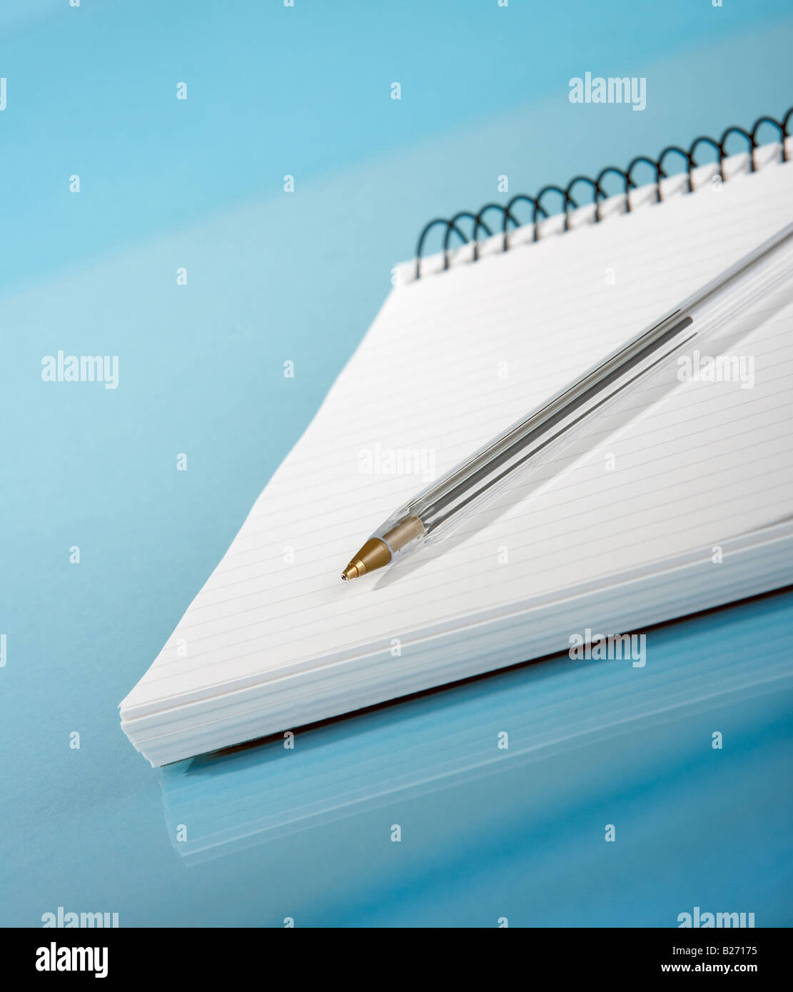 Pen and notepad arranged on a blue background Stock Photo - Alamy