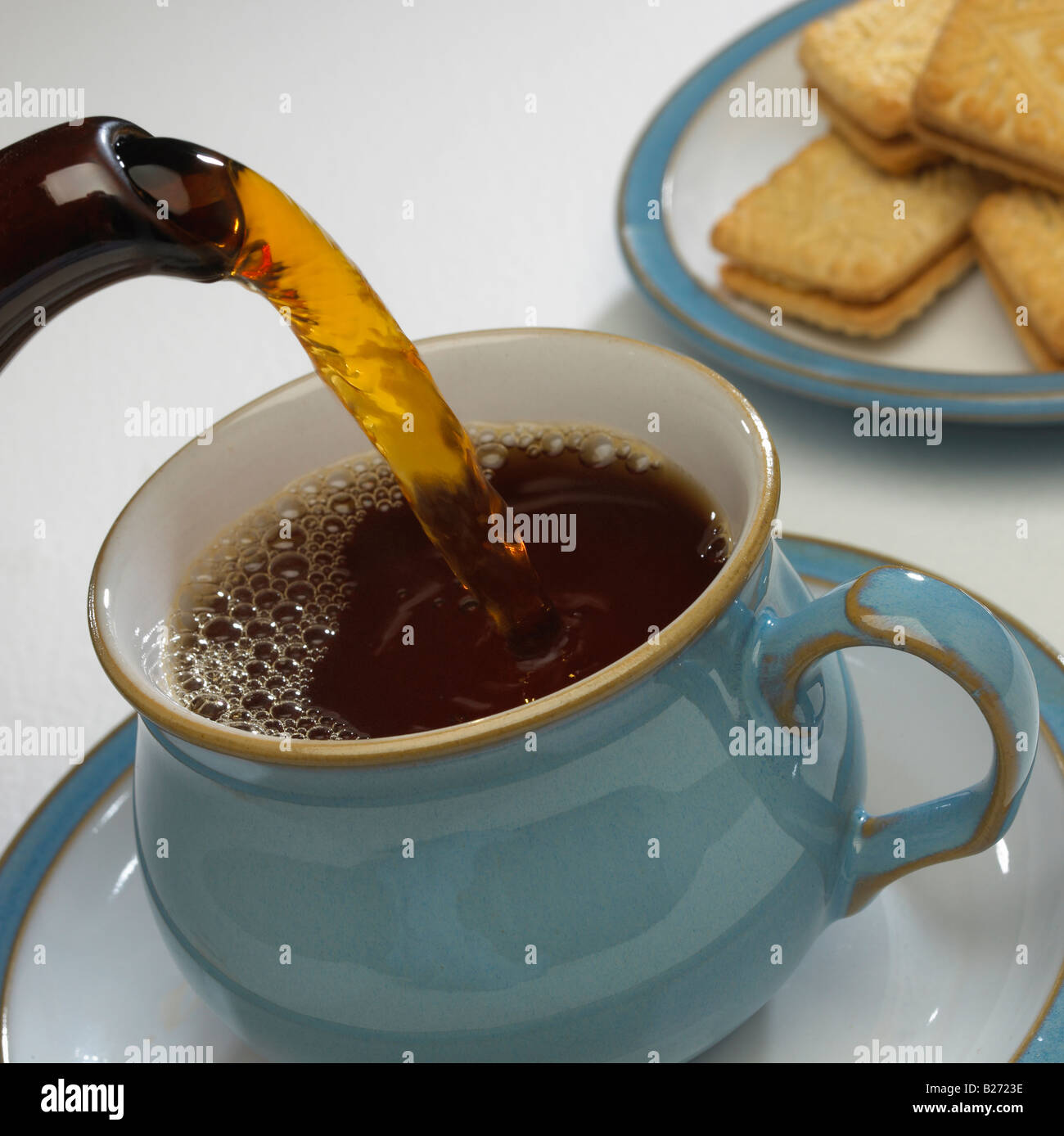 POURING CUP OF TEA WITH PLATE OF BISCUITS Stock Photo - Alamy