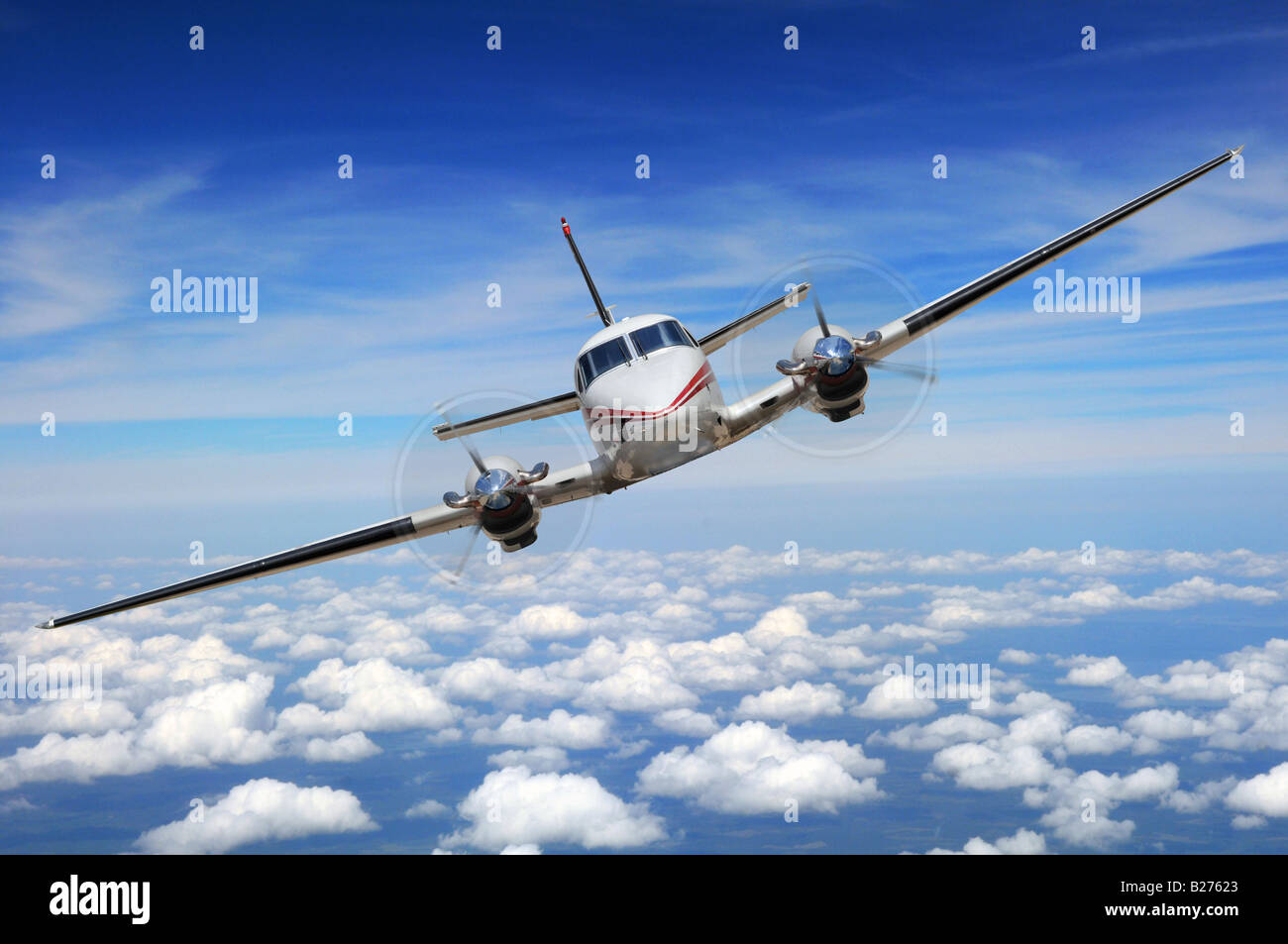 Corporate airplane in flight high above the clouds Stock Photo - Alamy