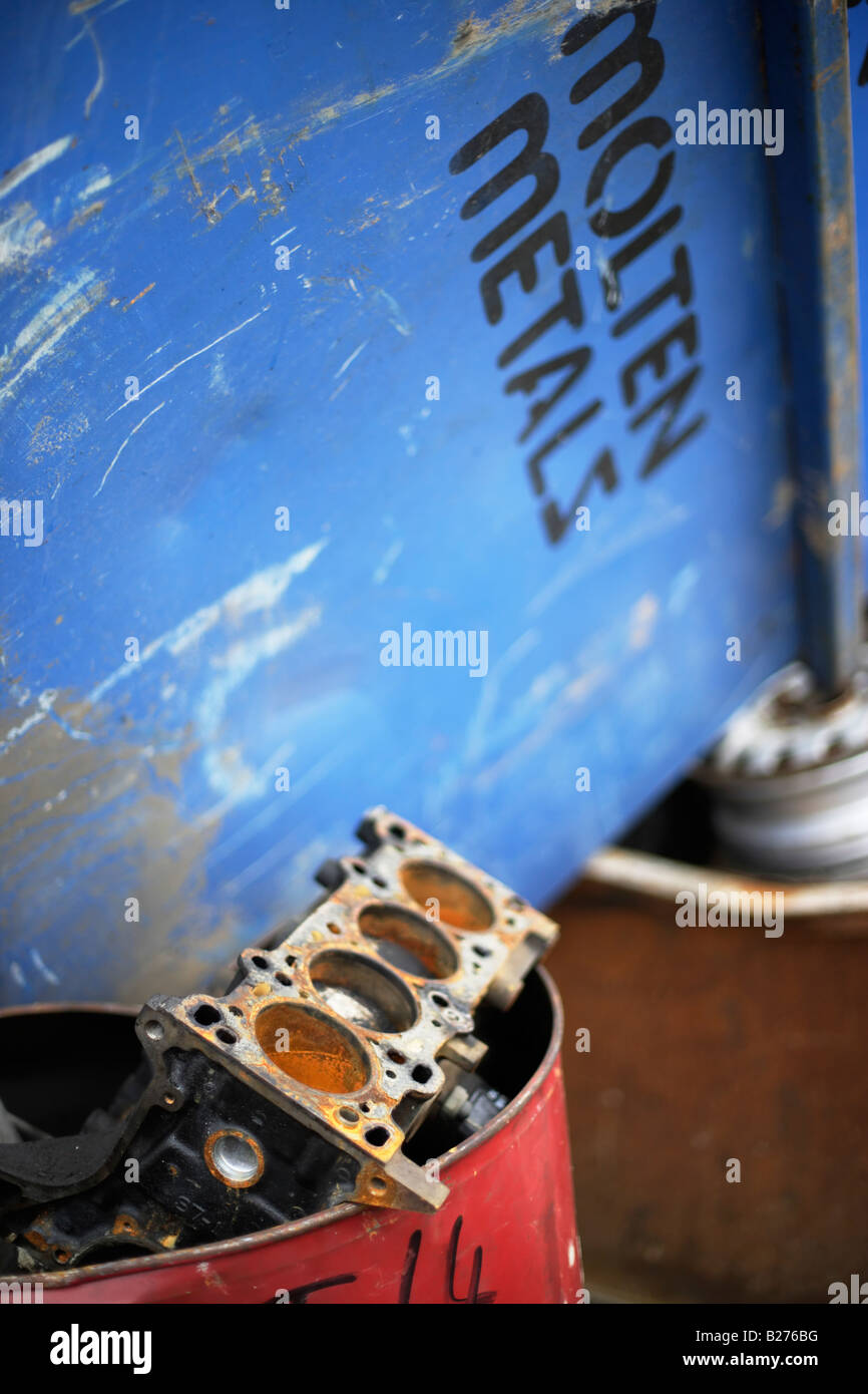 Car breakers yard New Zealand Engine block and molten metal bin Stock ...