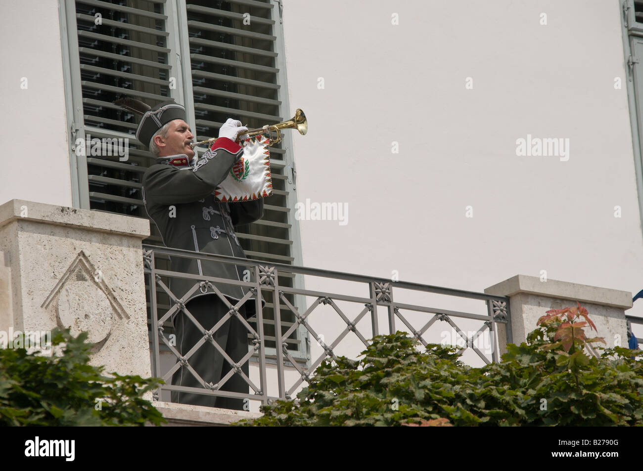 Hungarian Soldier in Ceremonial uniform sounds a trumpet from a balcony ...