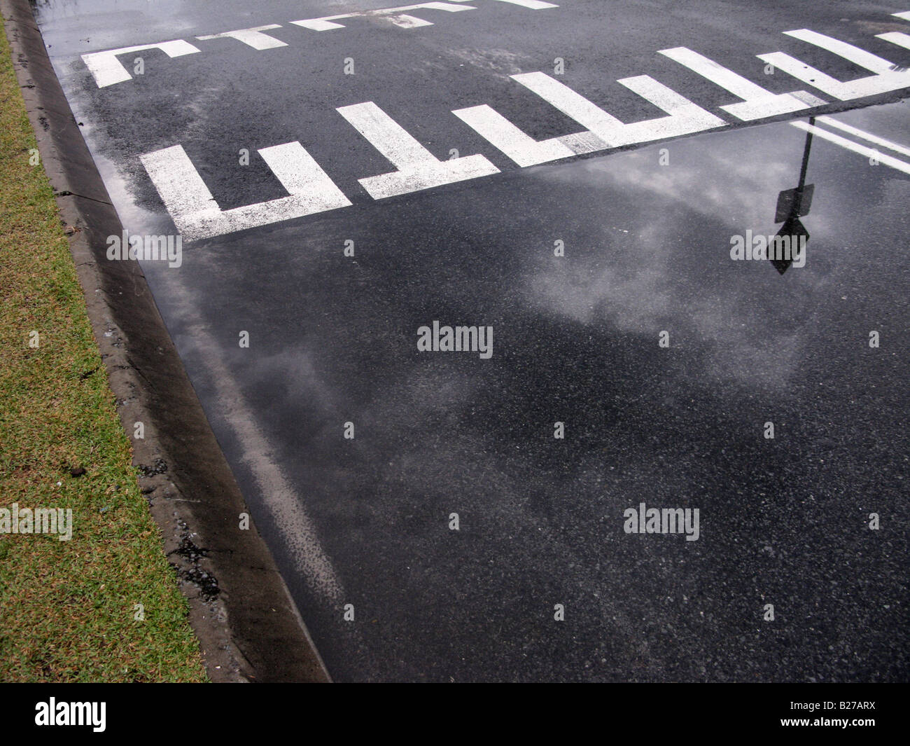 Pedestrian crossing with puddle and reflection of road sign Stock Photo ...