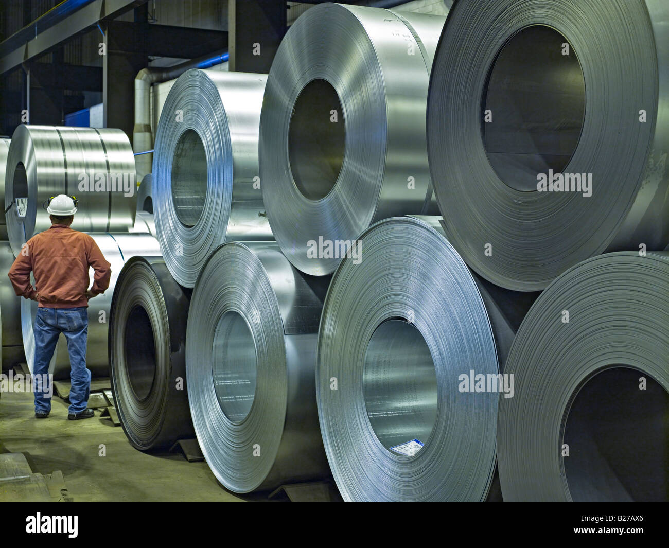 steel plate rolls at a steel factory with a non recognizable worker on ...