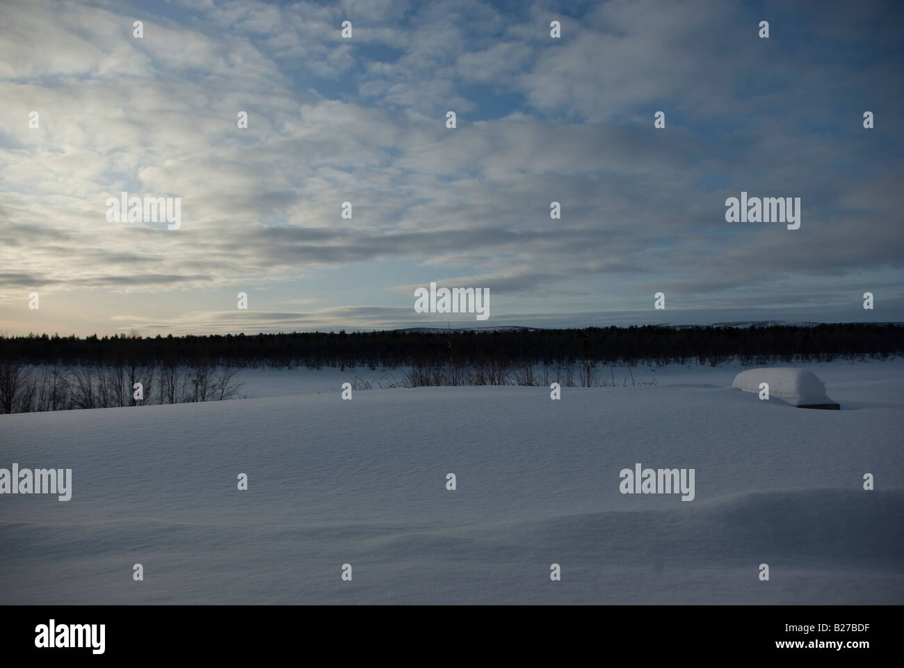 A bench covered in snow, with Tornio river and fells on Sweden's side ...