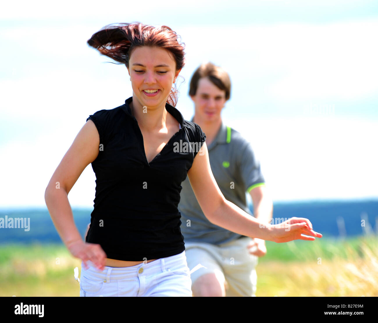 two teenagers running in a field Stock Photo - Alamy
