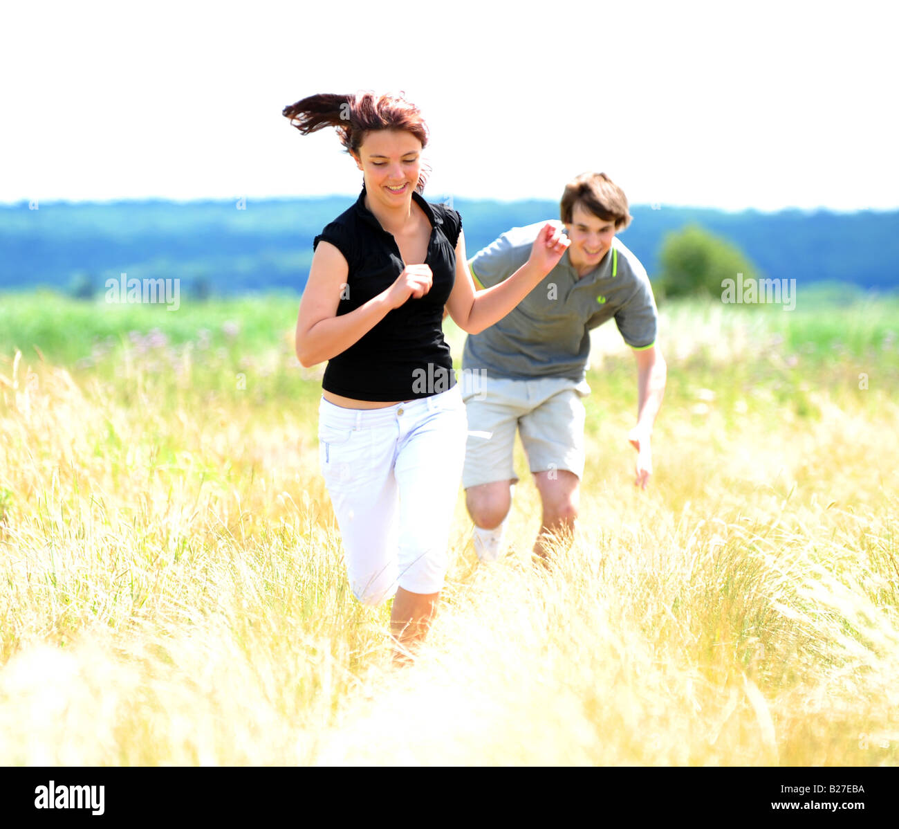 two teenagers running in a field Stock Photo - Alamy