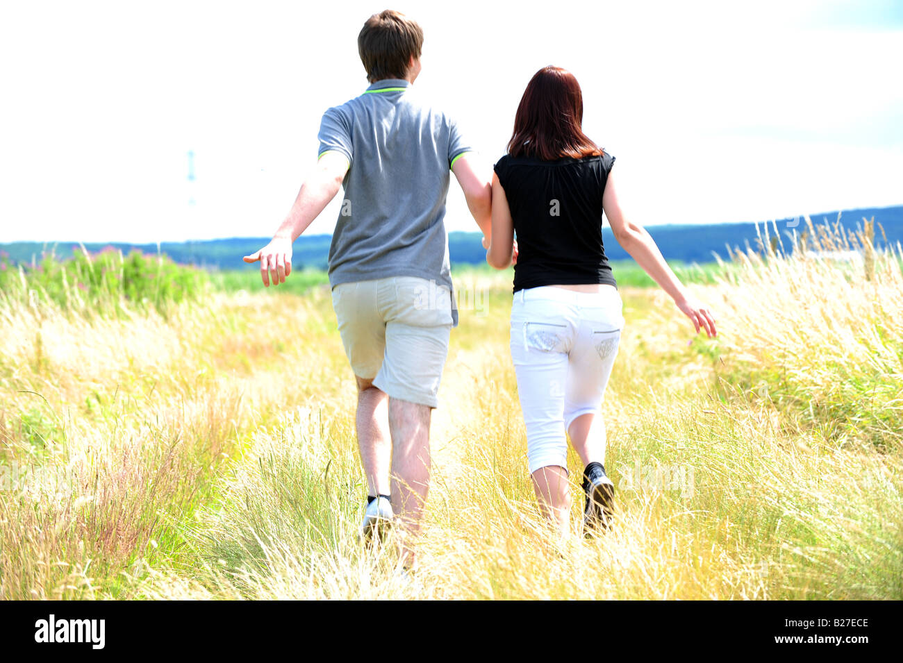 two teenagers running in a field Stock Photo - Alamy