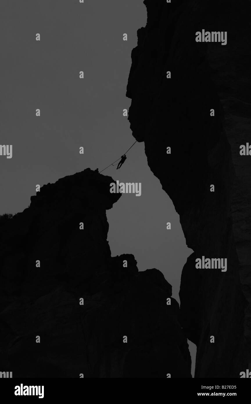 A climber slides across a rope line high above the ground between two ...