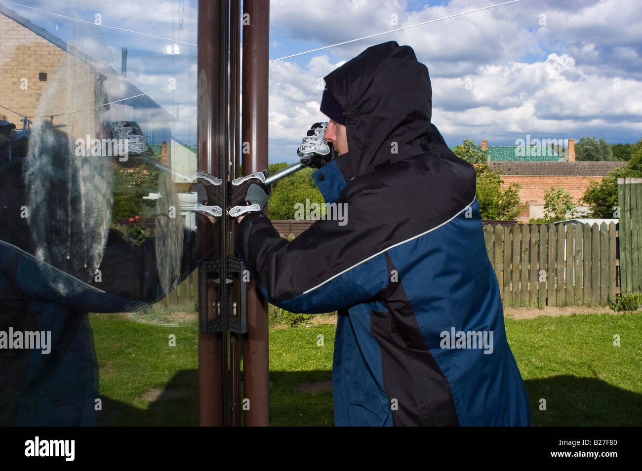 Burglar breaking into a house though a window Stock Photo - Alamy