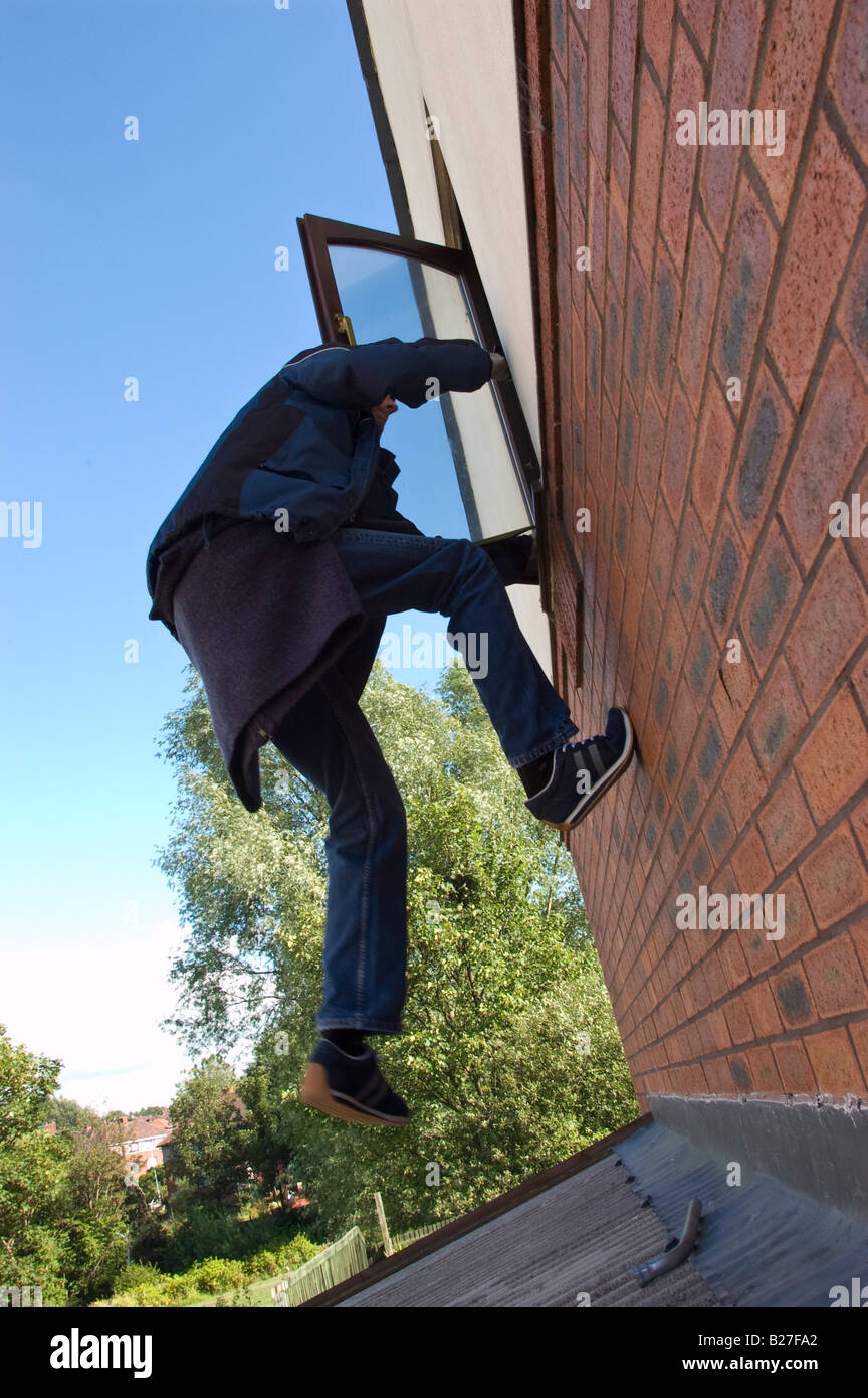 Burglar breaking into a house by climbing in a window Stock Photo - Alamy
