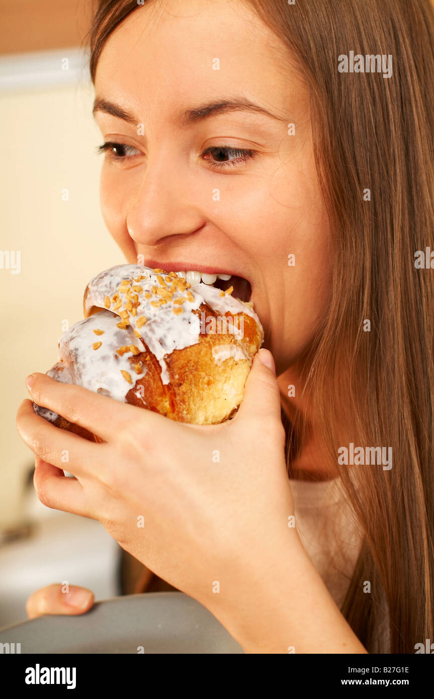 Young beautiful women eating cake in kitchen Stock Photo - Alamy