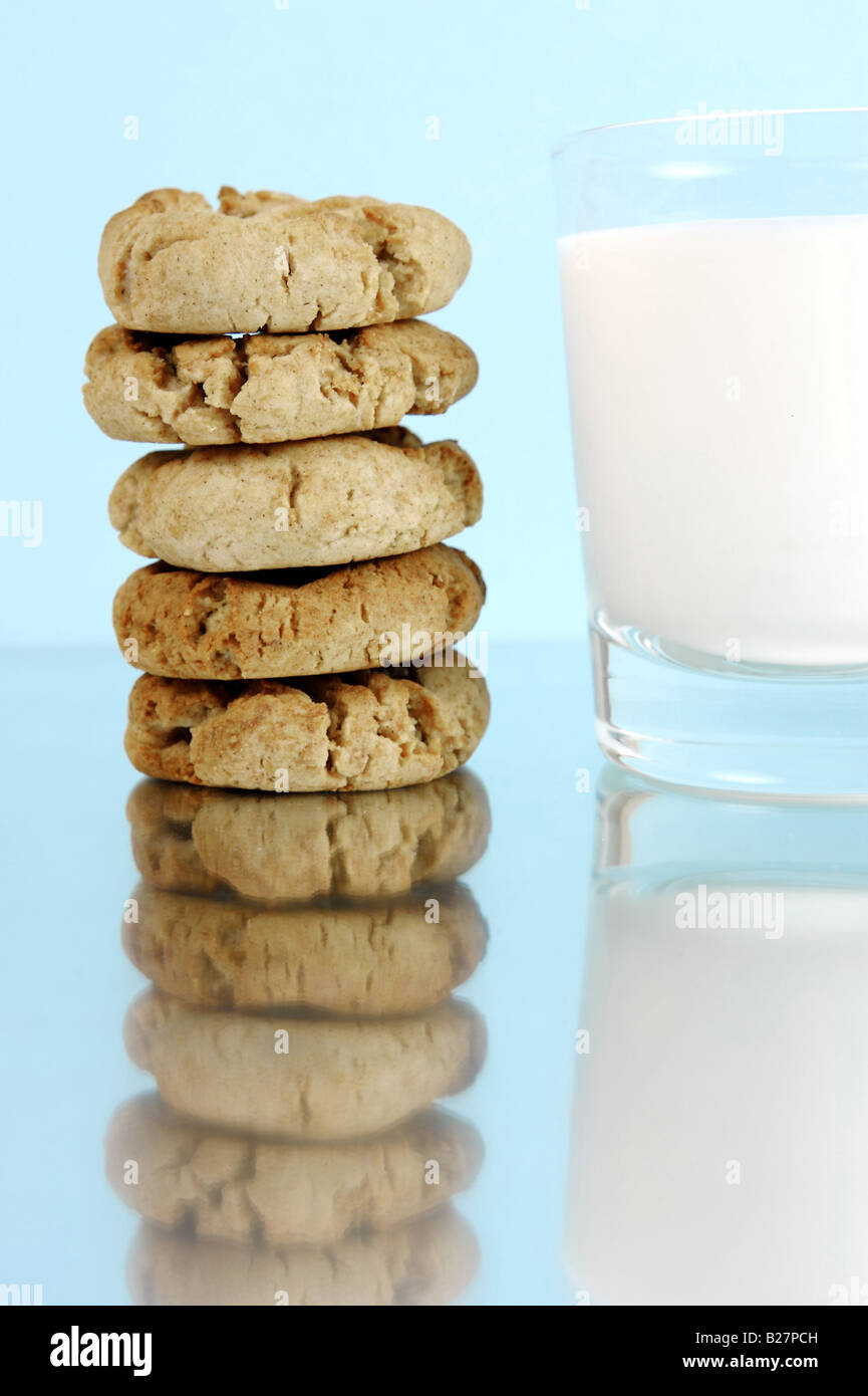 Milk and cookies isolated against a blue background Stock Photo - Alamy
