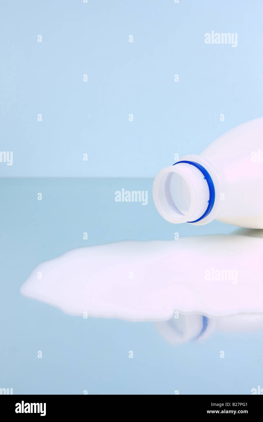 Spilt full cream milk isolated against a blue background Stock Photo ...