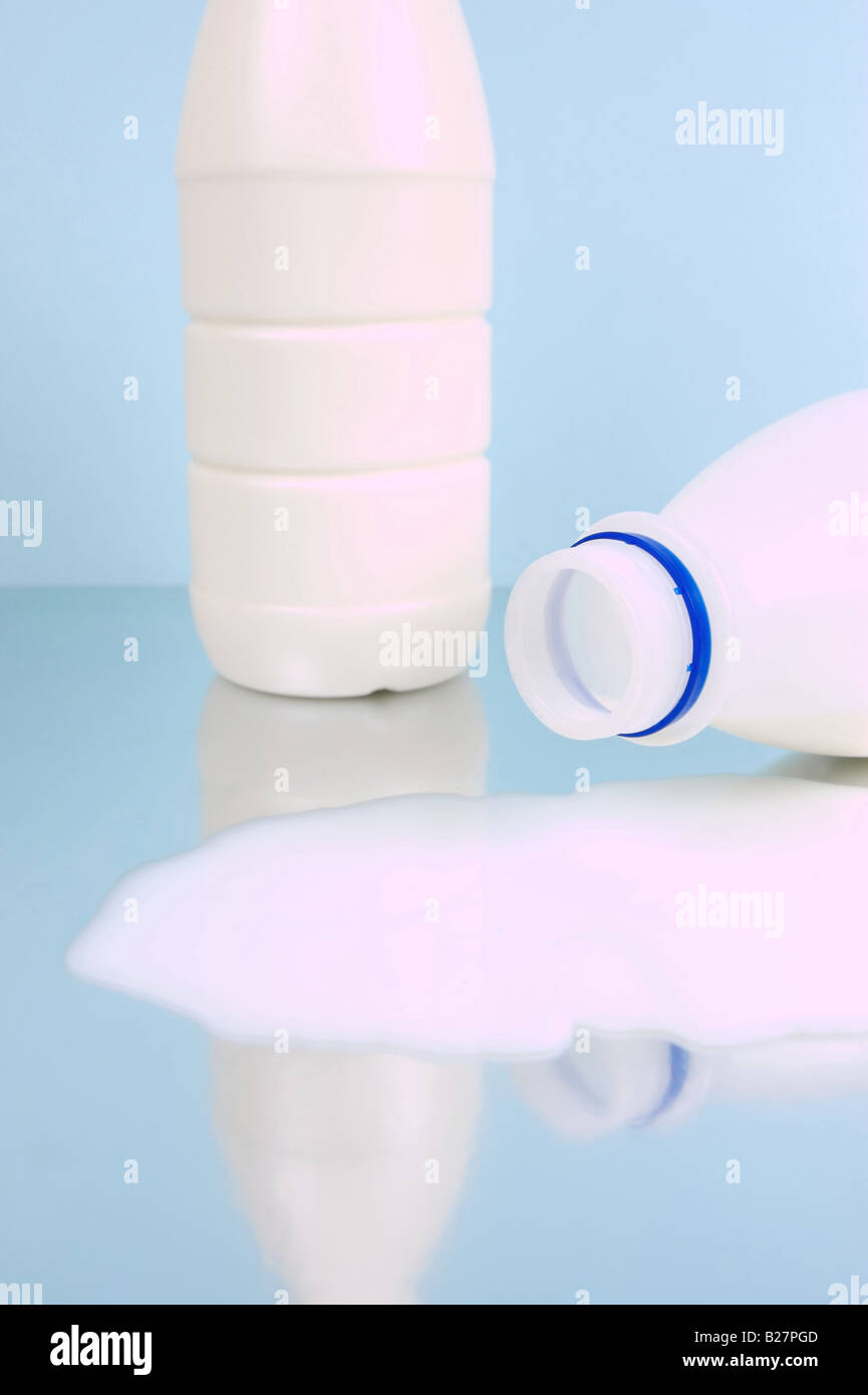 Spilt full cream milk isolated against a blue background Stock Photo ...