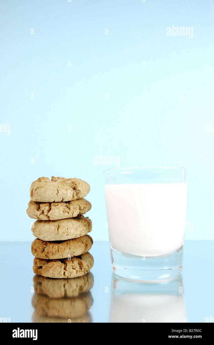 Milk and cookies isolated against a blue background Stock Photo - Alamy