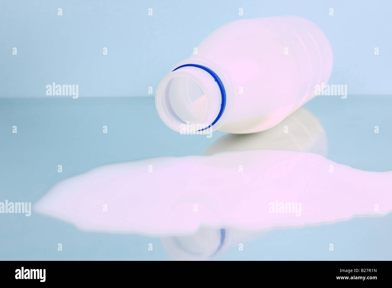 Spilt full cream milk isolated against a blue background Stock Photo ...