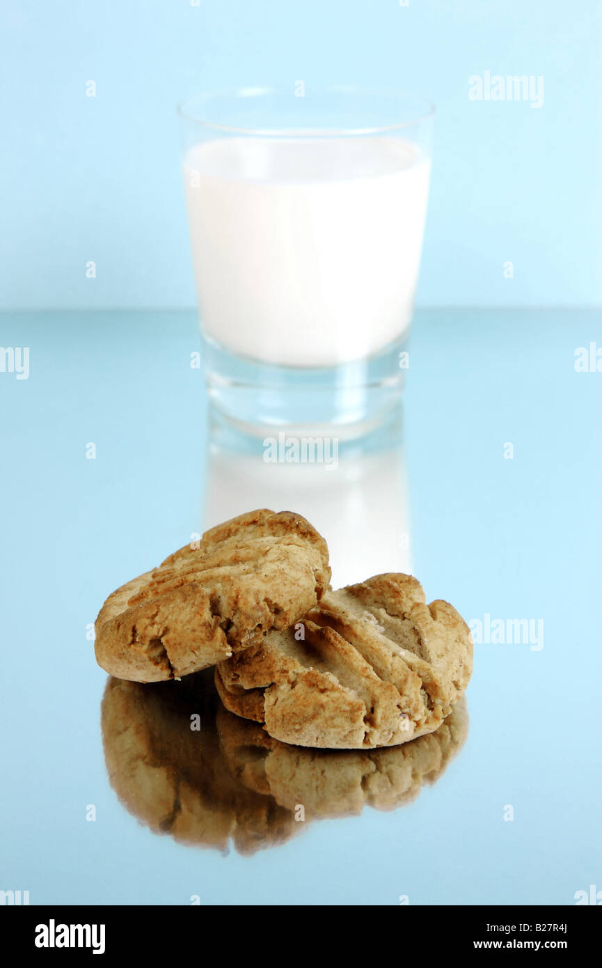 Milk and cookies isolated against a blue background Stock Photo - Alamy
