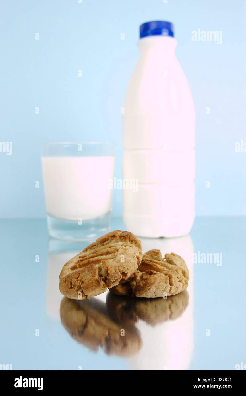 Milk and cookies isolated against a blue background Stock Photo - Alamy