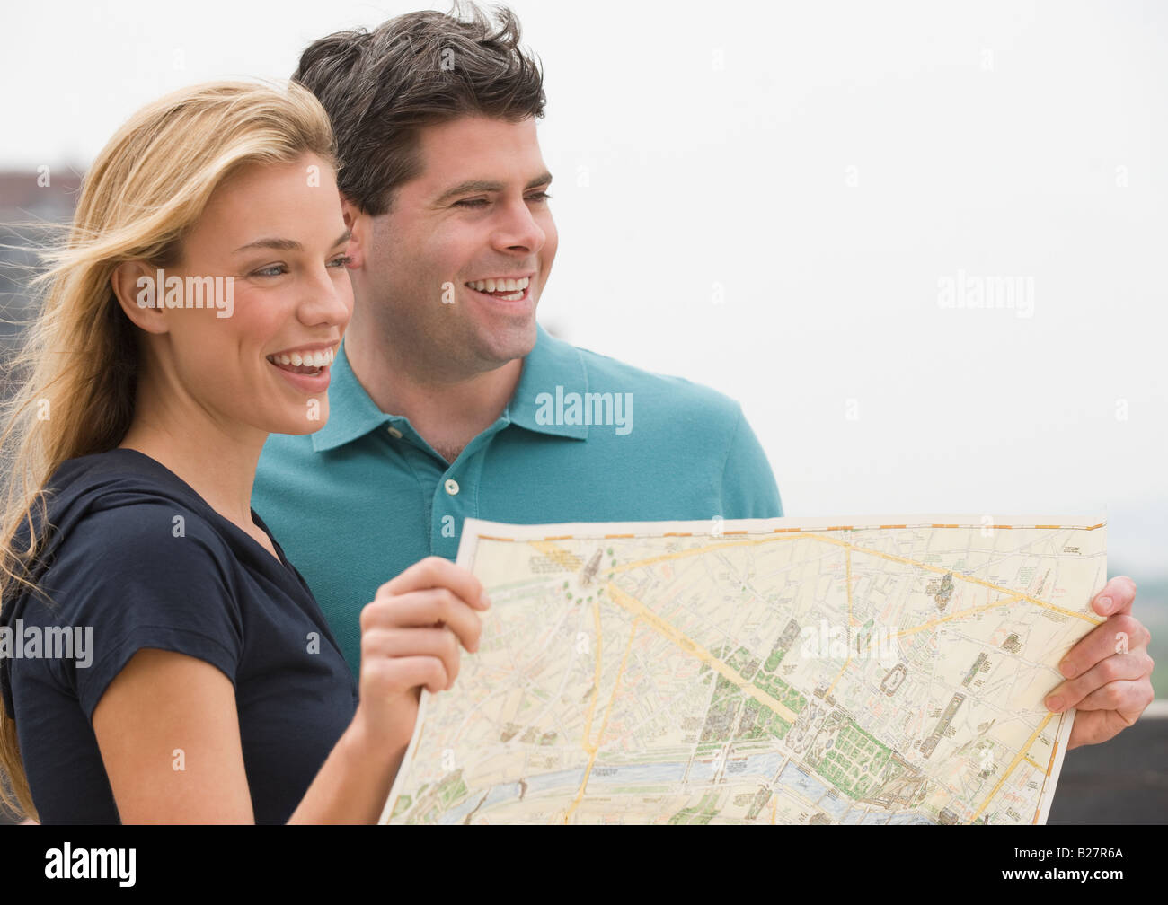 Couple holding map Stock Photo - Alamy