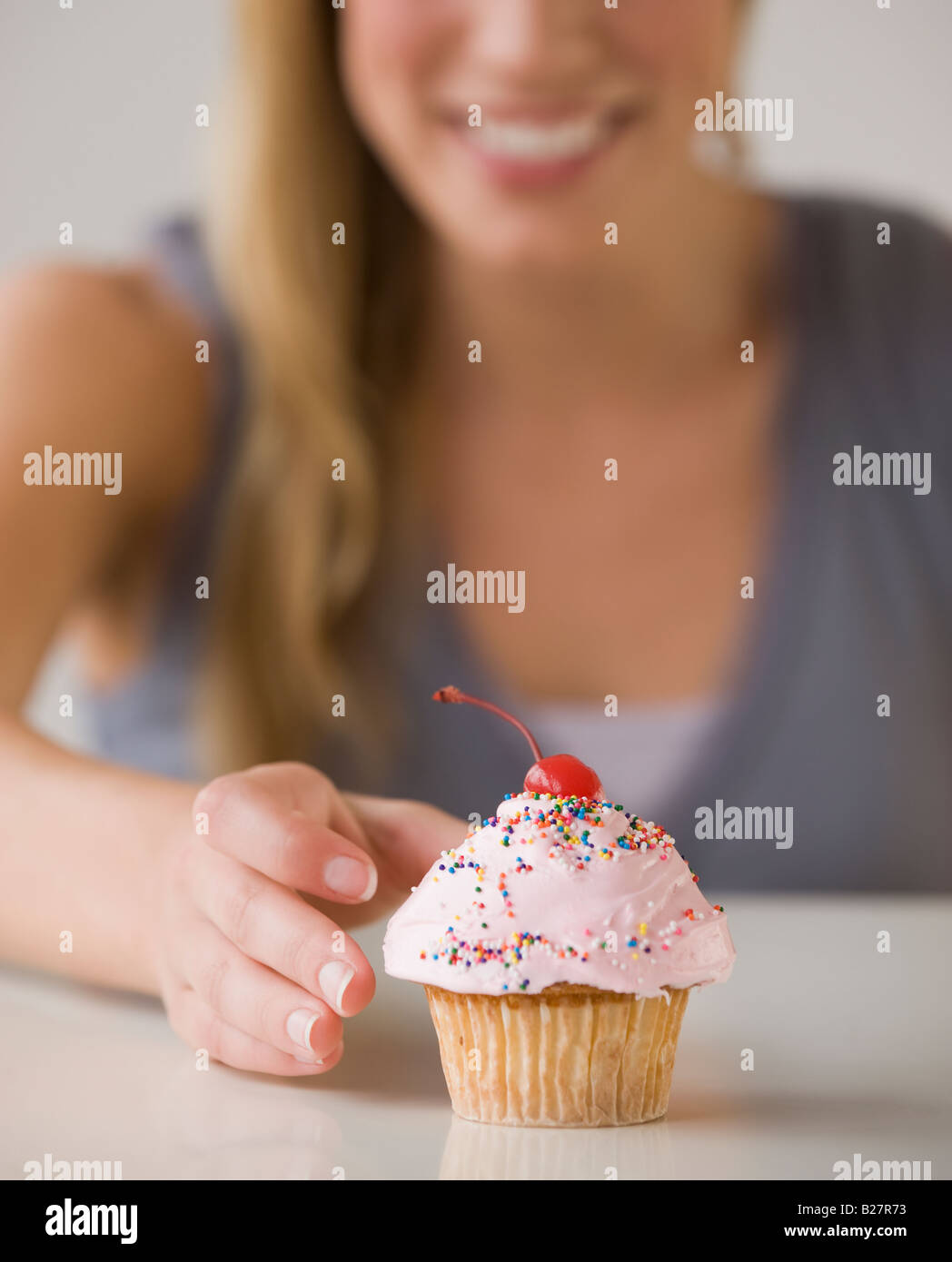 Woman reaching for cupcake Stock Photo - Alamy