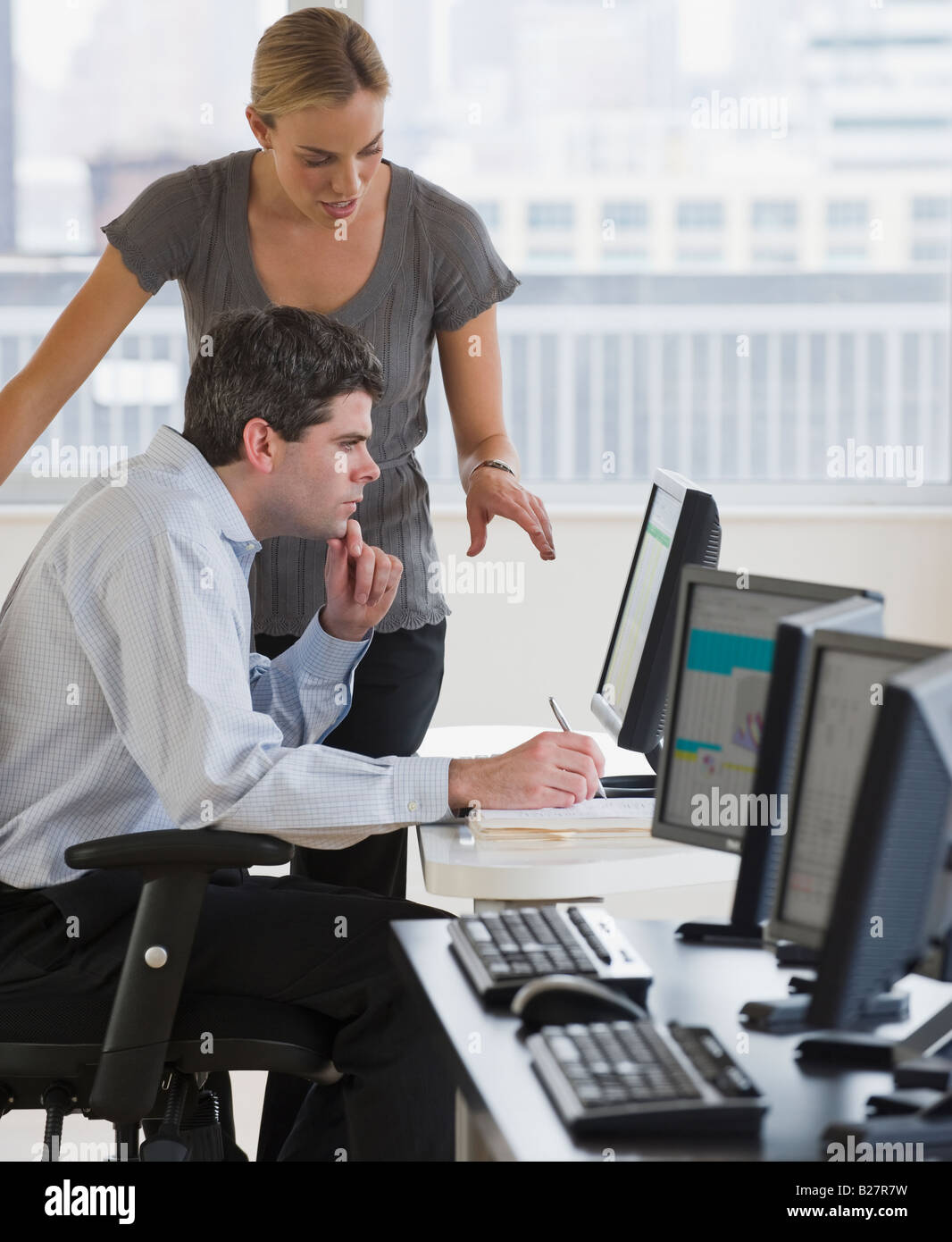 Businesspeople looking at computer Stock Photo - Alamy