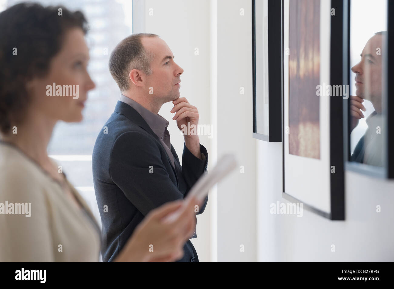 Couple looking at art in art gallery Stock Photo - Alamy