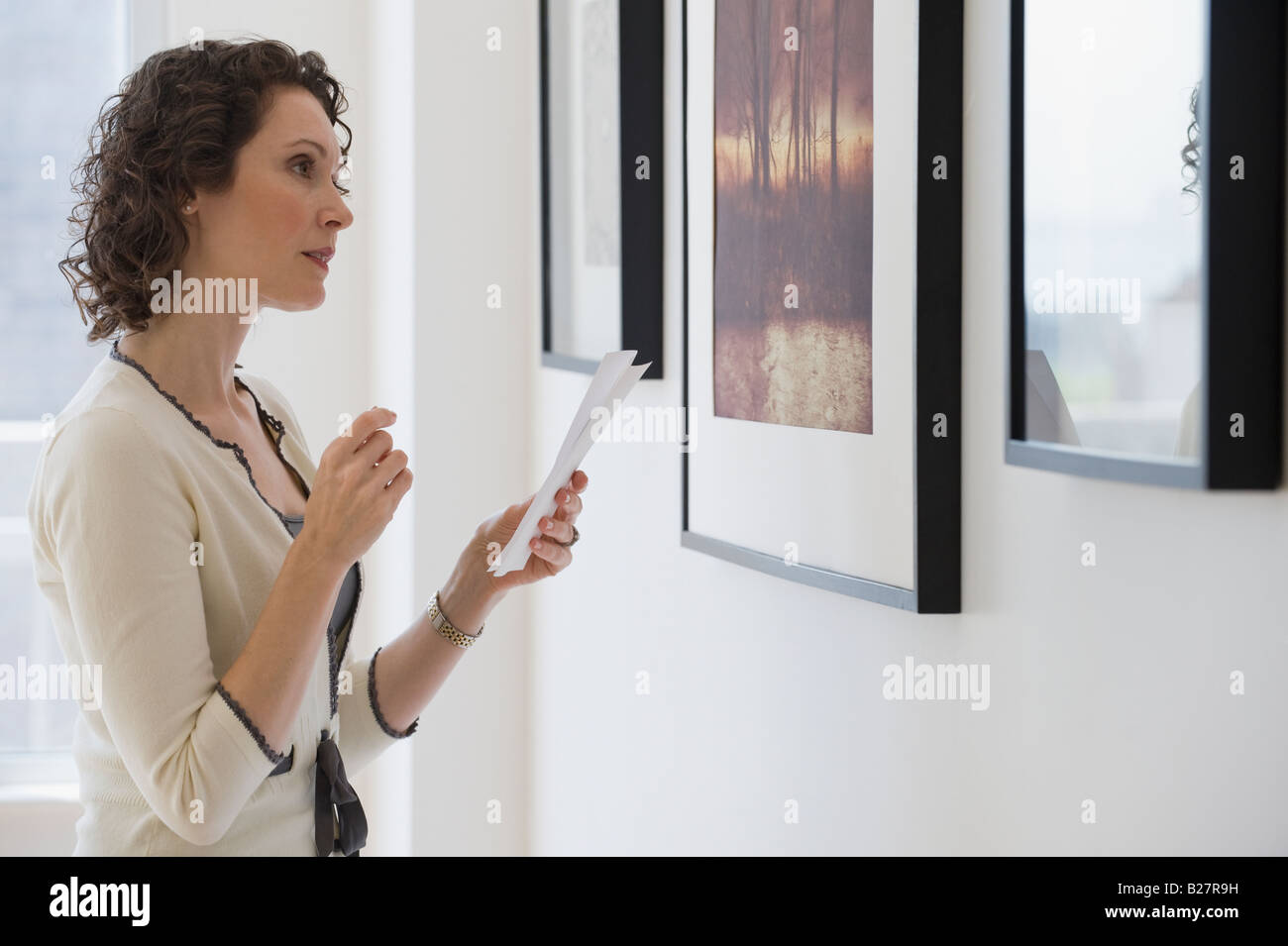 Woman looking at art in art gallery Stock Photo - Alamy