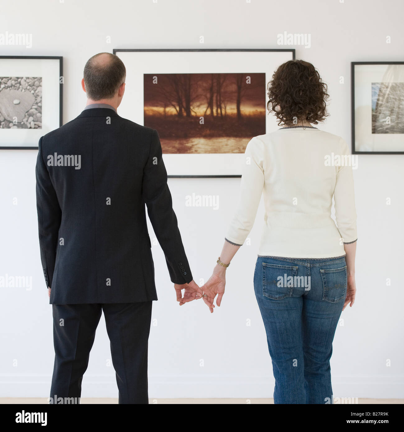 Couple looking at art in art gallery Stock Photo - Alamy