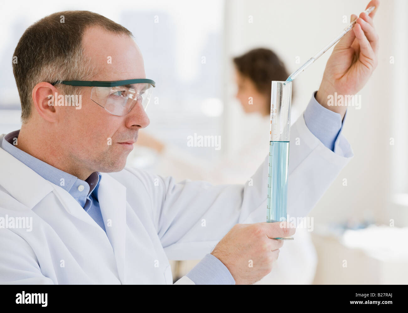 Male scientist measuring liquid in vial Stock Photo - Alamy