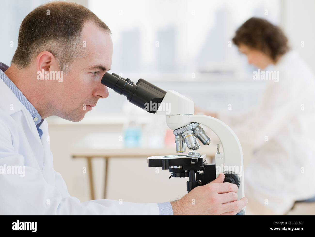 Male scientist looking into microscope Stock Photo - Alamy