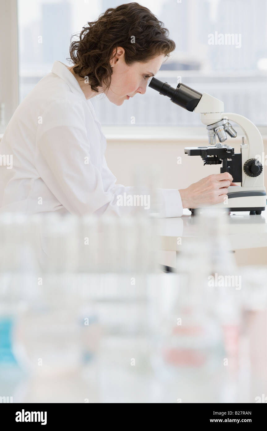 Female scientist looking into microscope Stock Photo - Alamy