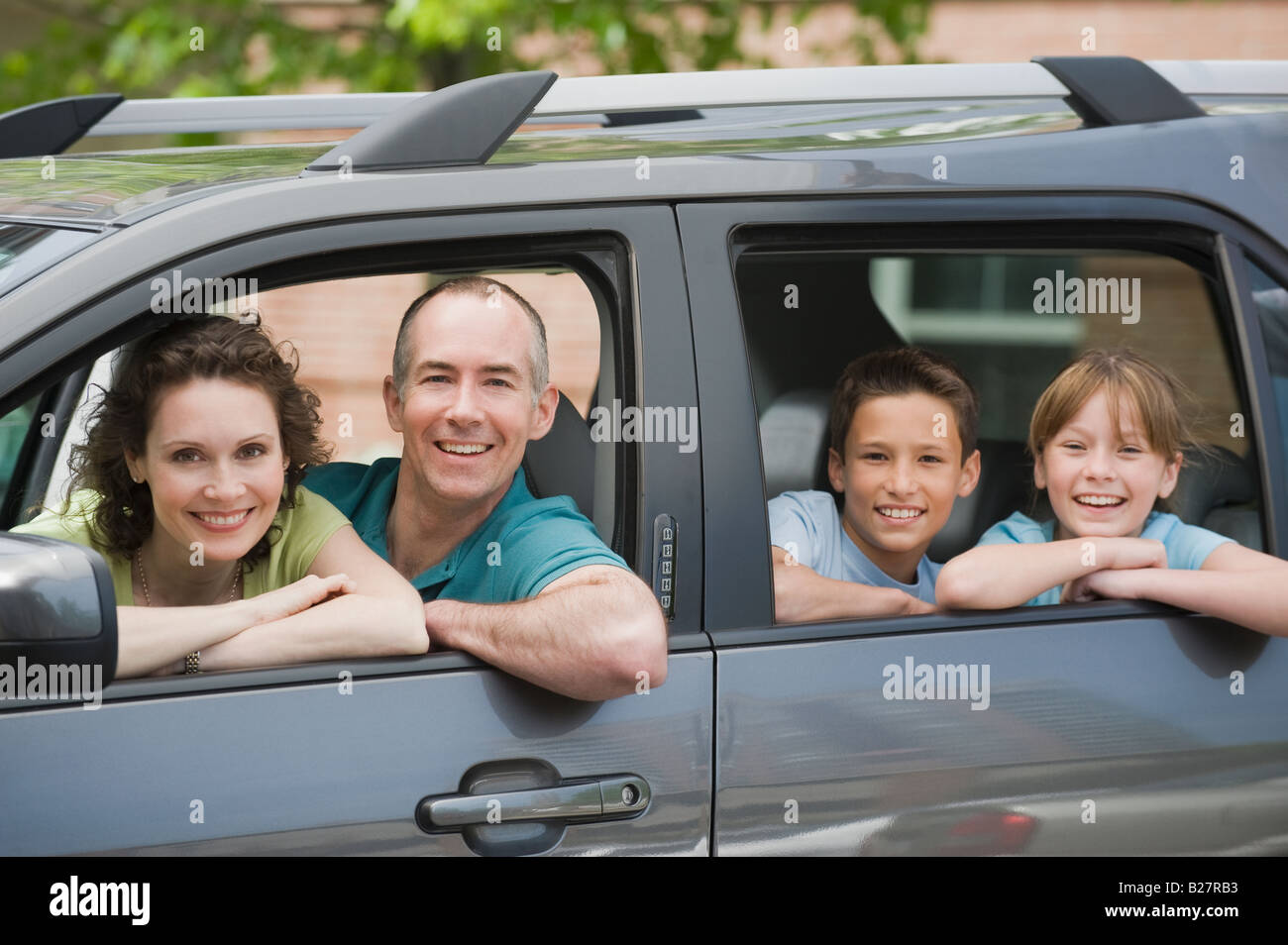 Family with two children looking out car windows Stock Photo - Alamy