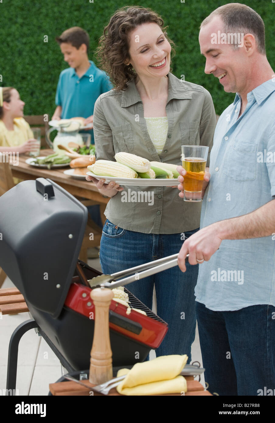 Family with two children barbecuing Stock Photo - Alamy