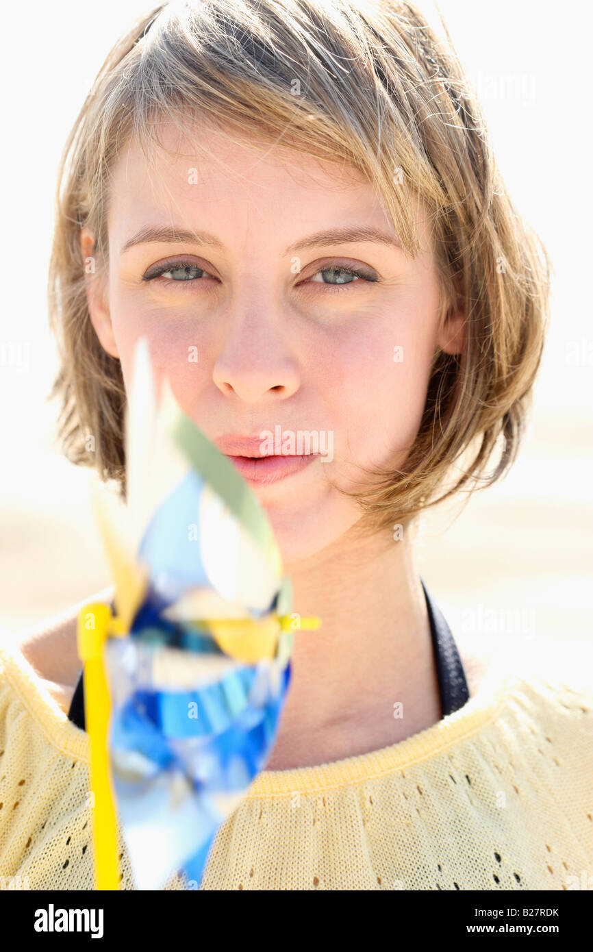 Woman blowing on pinwheel Stock Photo - Alamy