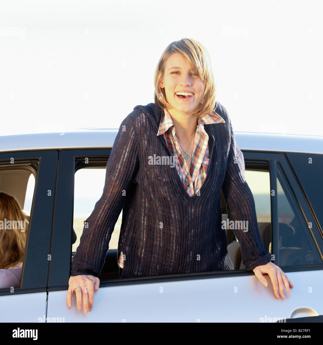 Woman leaning out of car window Stock Photo - Alamy