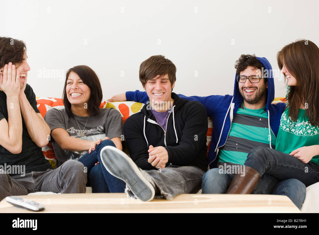 Group of friends sitting on sofa Stock Photo - Alamy