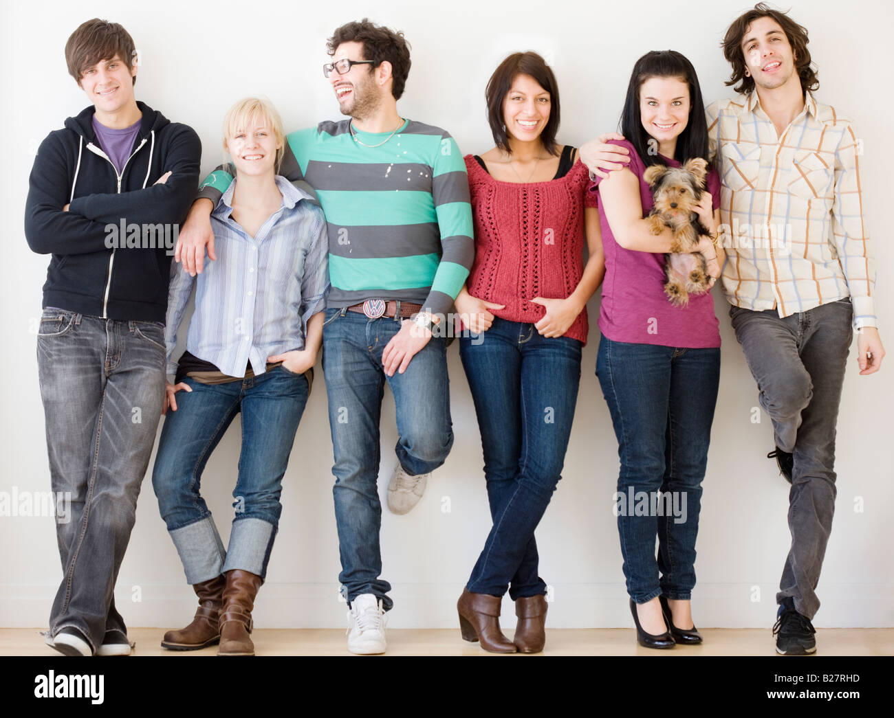 Group of friends leaning on wall Stock Photo - Alamy