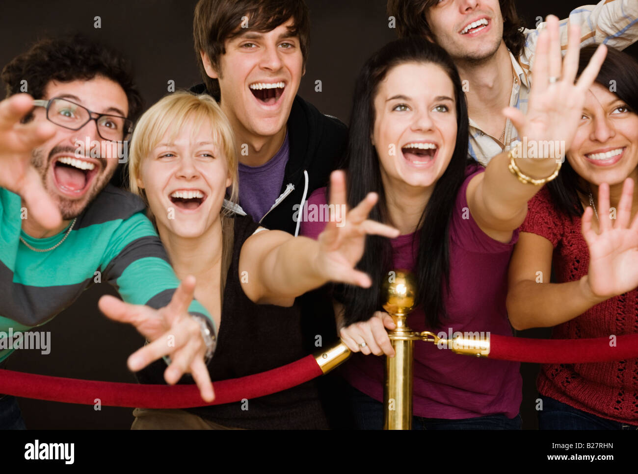 group of people reaching across velvet rope Stock Photo - Alamy
