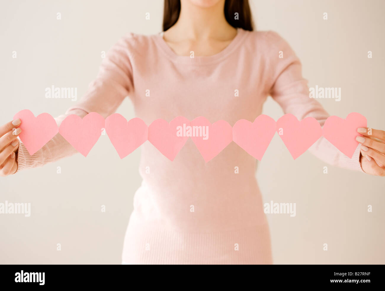Woman holding string of cut out hearts Stock Photo - Alamy