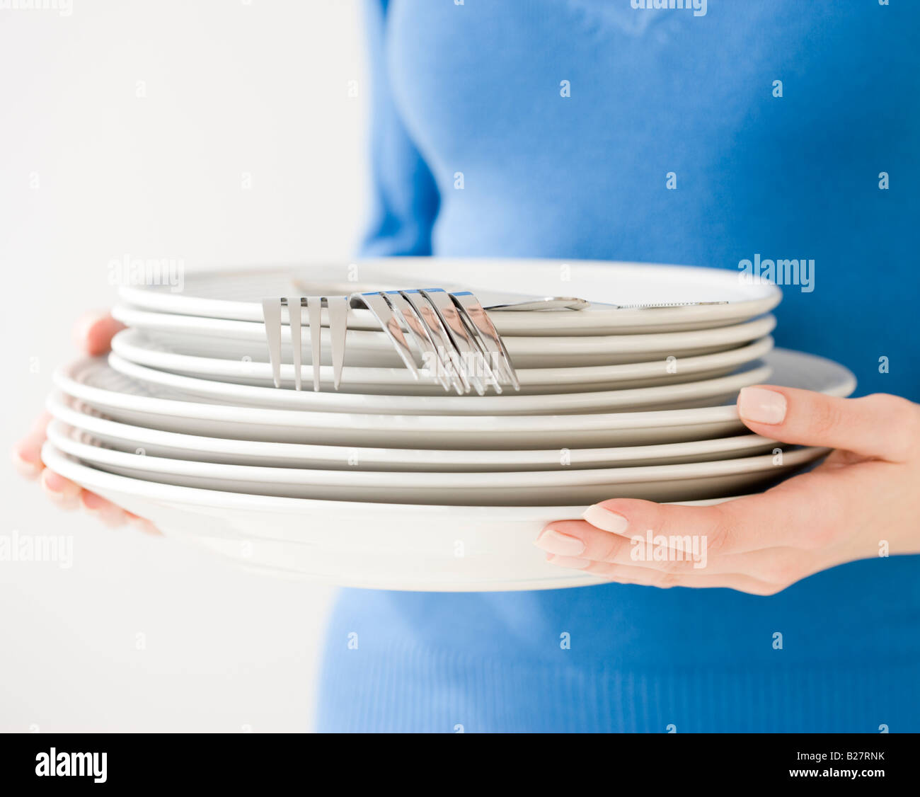 Woman holding stack of dishes Stock Photo - Alamy