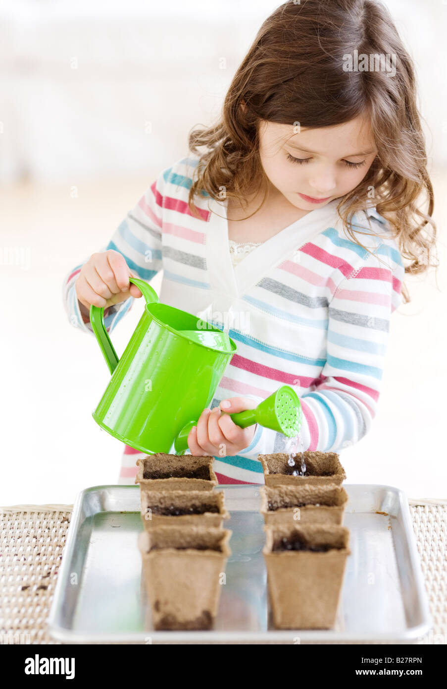 Girl watering small potted plants Stock Photo - Alamy