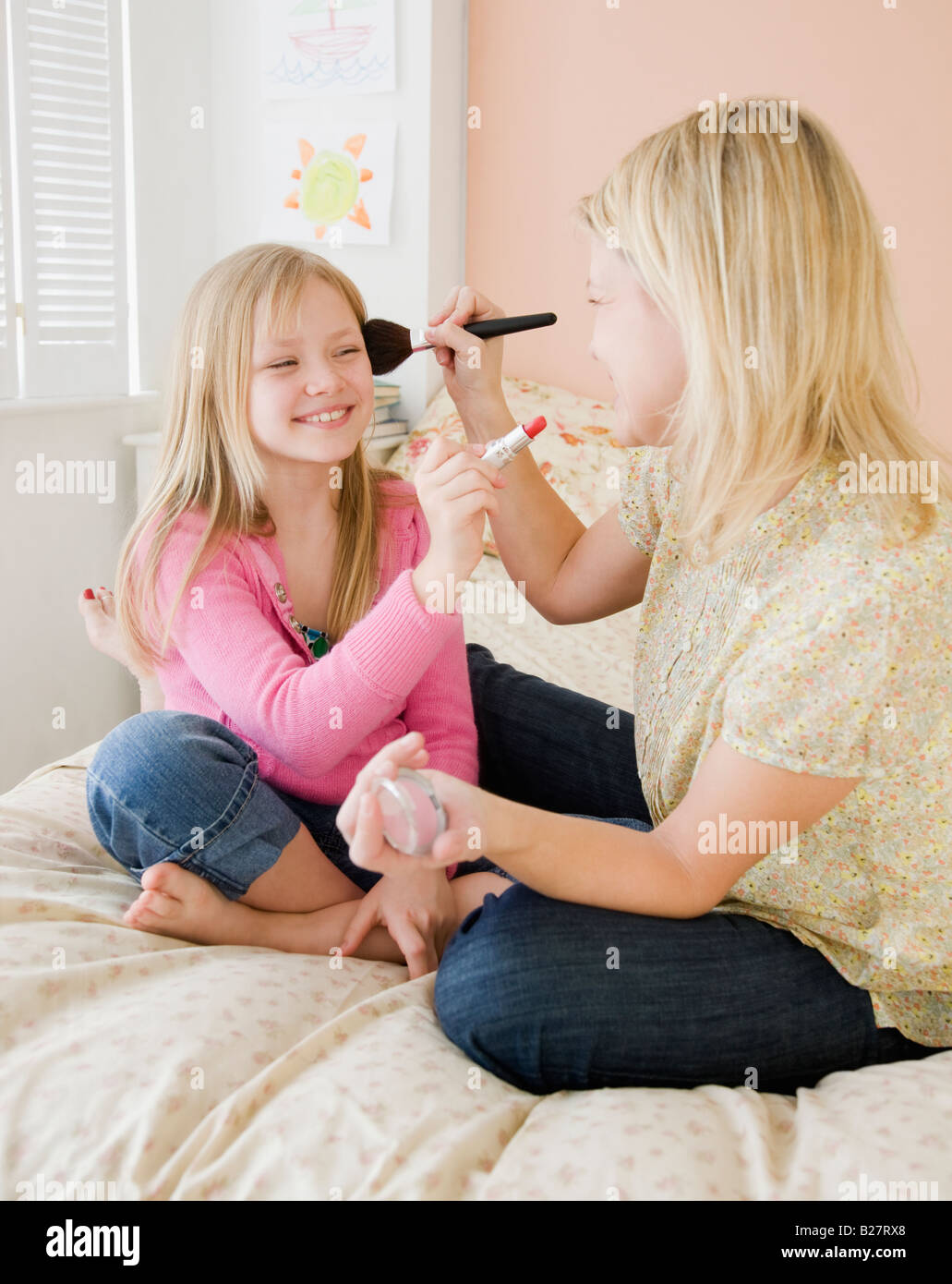 Mother and daughter applying makeup Stock Photo - Alamy