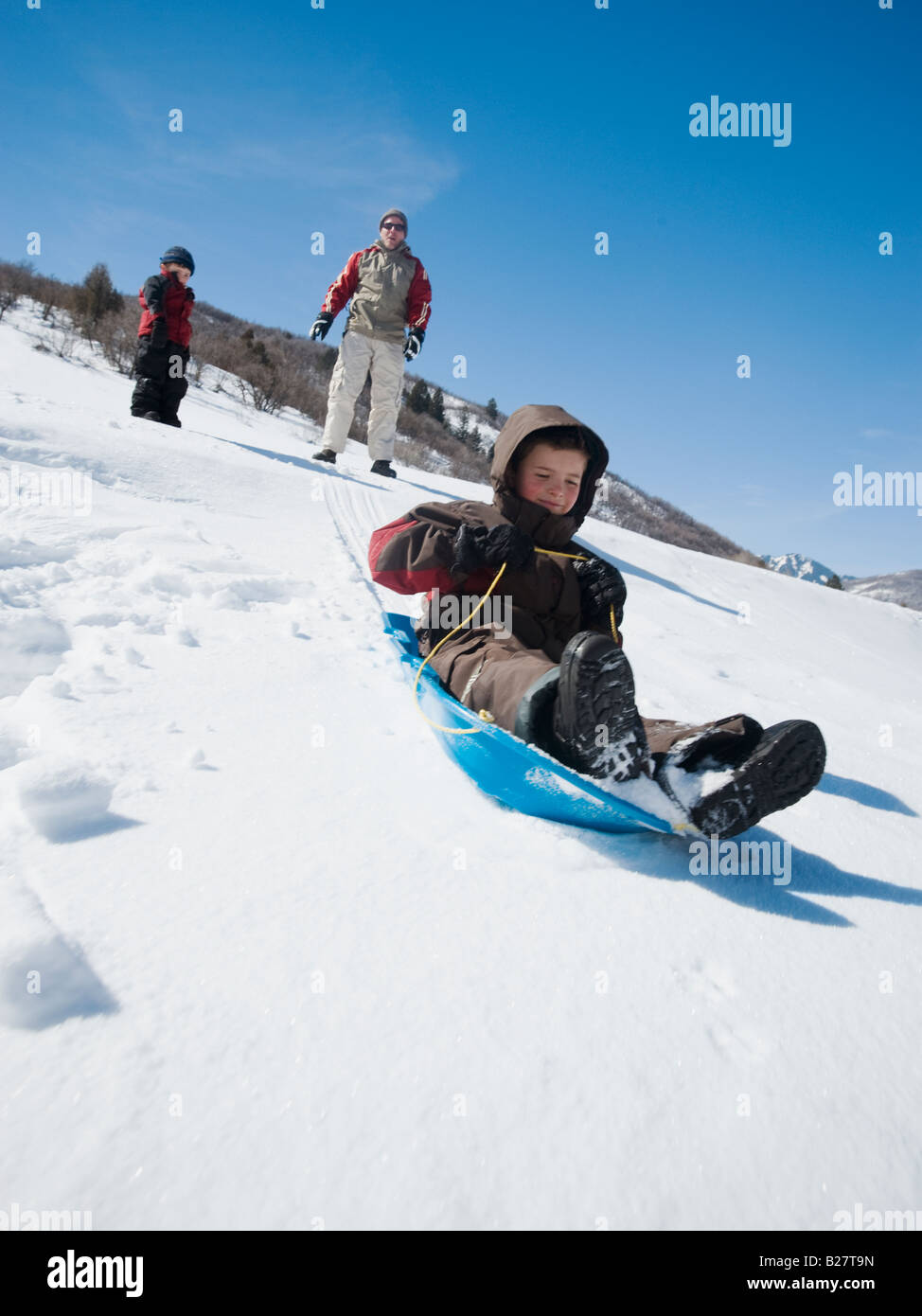 Boy riding on sled Stock Photo - Alamy