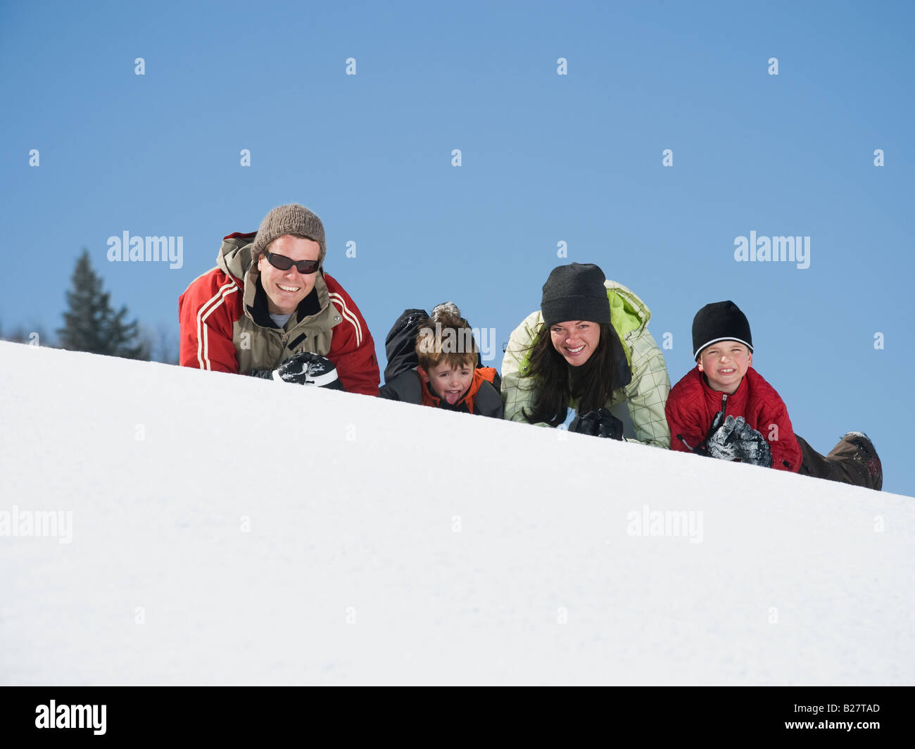 Family laying in snow Stock Photo - Alamy