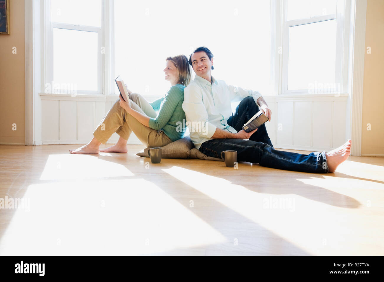 Couple reading back to back Stock Photo - Alamy