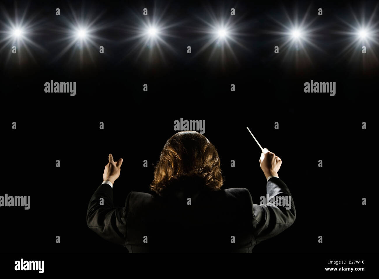 Man conducting under lights Stock Photo - Alamy